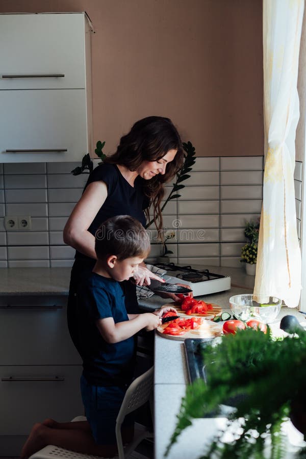Little Son Helps Mom Cook Vegetable Salad Cuts Vegetables in Kitchen ...