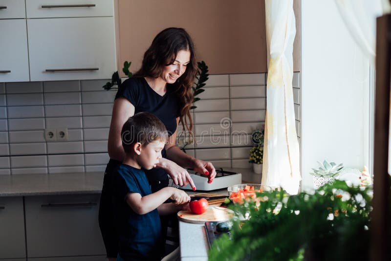 Little Son Helps Mom Cook Vegetable Salad Cuts Vegetables in Kitchen ...
