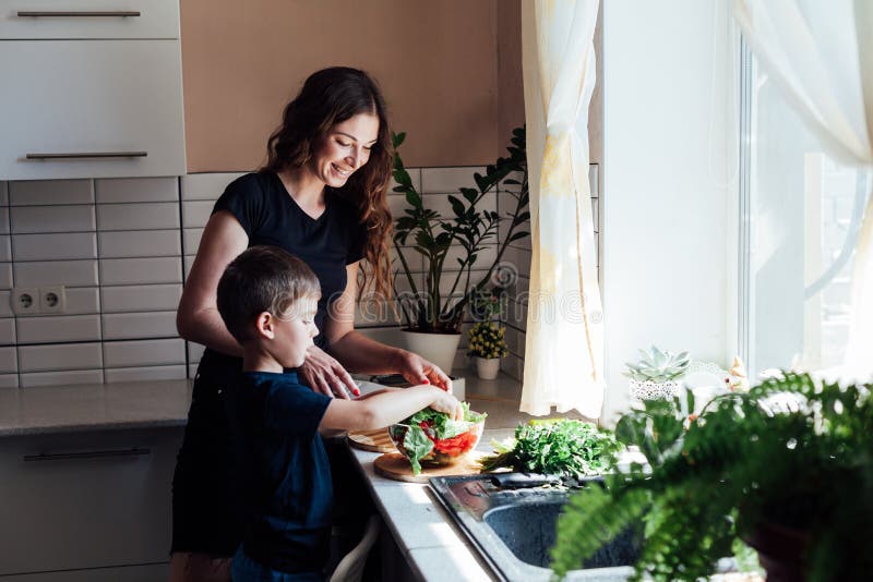 Little Son Helps Mom Cook Vegetable Salad in the Kitchen Stock Image ...
