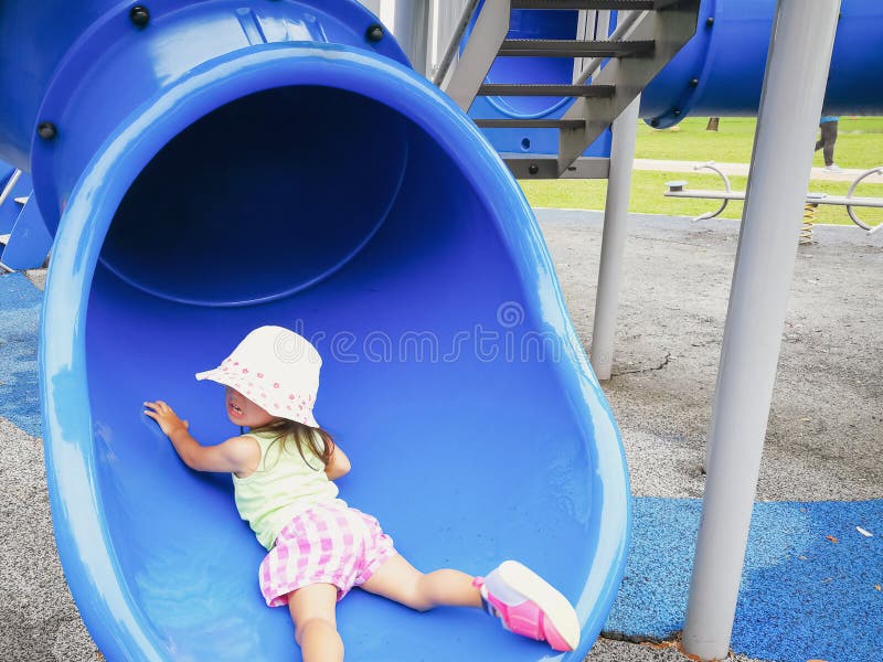 Little Toddler Girl Playing at the Slide. Doing an Upside-down Position ...