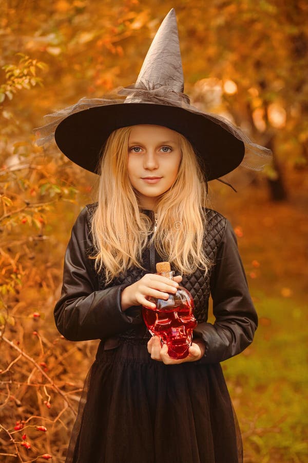 The Little Witch is Holding a Bottle Shaped Like a Skull with a Potion ...