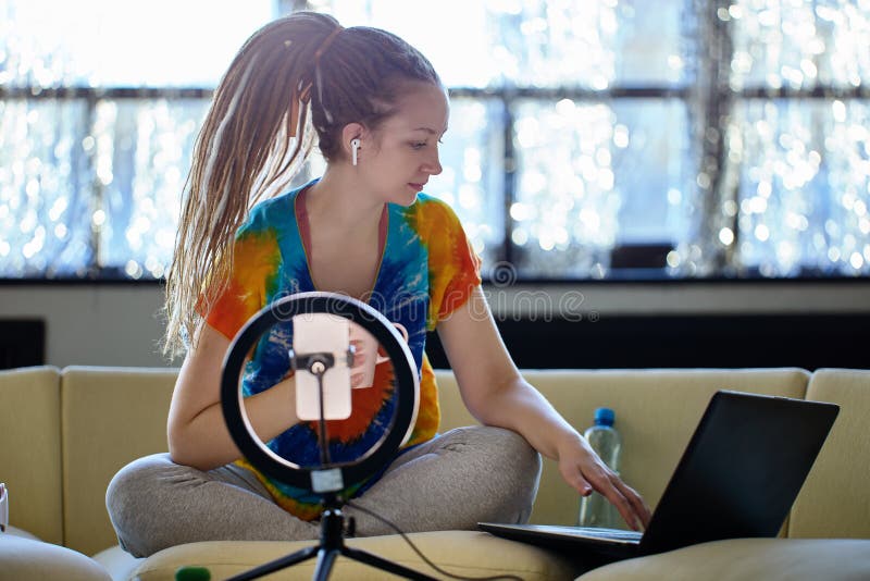 Live Streaming by Woman with Dreadlocks Using Laptop and Ring Light ...