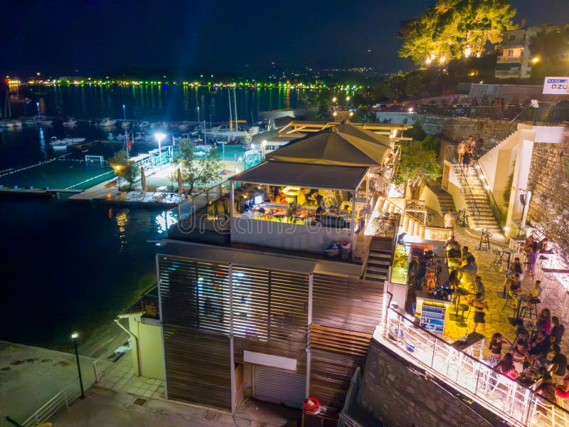Lively Outdoor Bar and Restaurant Scene Illuminated at Night by the ...