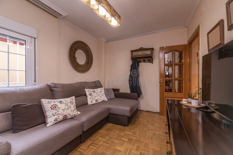 Living Room of a House with a Sofa Covering a Wall in Front of a Tv ...