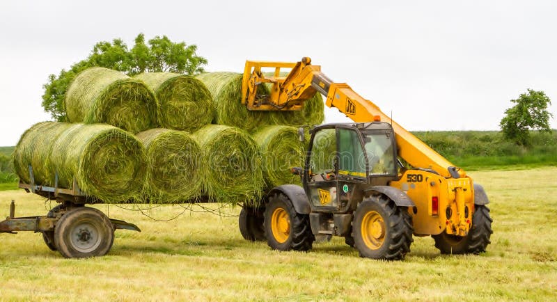 Loader Tractor Moving a Round Bale from Field Editorial Image - Image ...