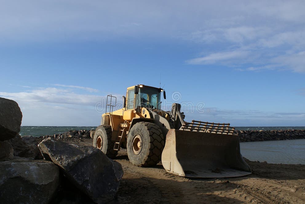 Loader working near coast stock photo. Image of machinery - 60636436