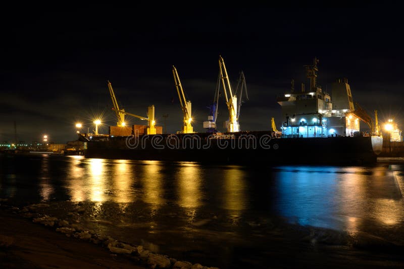 The Loading Cargo Ship with Cranes is Moored in Port at Night Stock ...