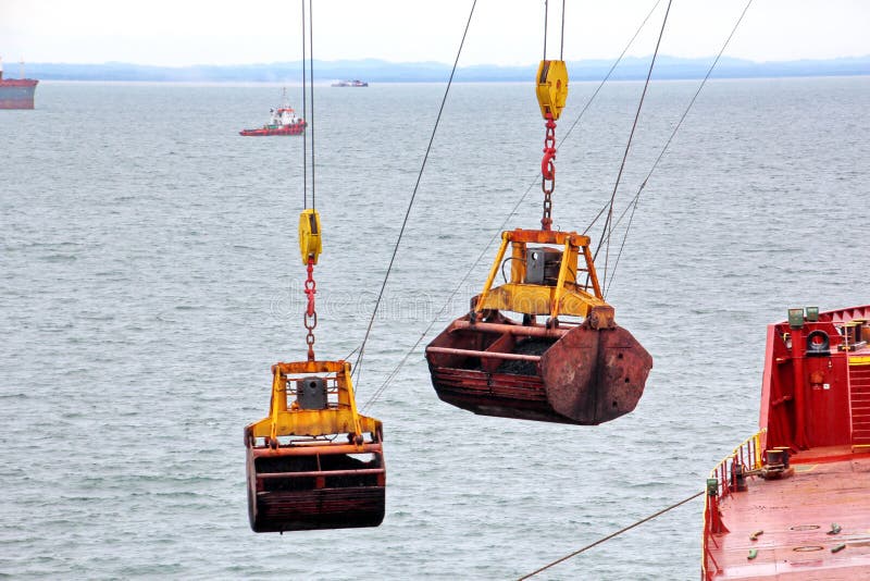 Loading Coal from Cargo Barges Onto a Bulk Carrier Using Ship Cranes ...