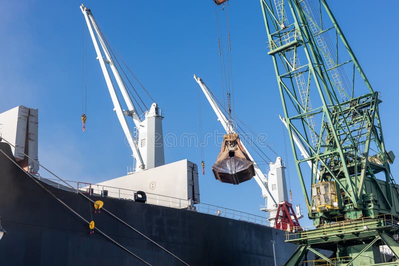 Loading Dry Cargo Ship by Cranes in Port. Loading into Holds of Sea ...