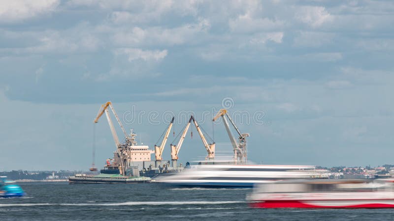 Loading and Unloading a Cargo Freight Ship with Industrial Cranes in the Middle of River ...