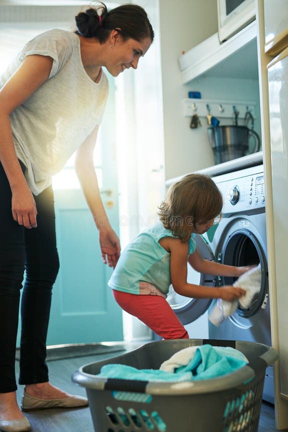 Loading the Washing Machine. a Mother and Daughter Using a Washing ...