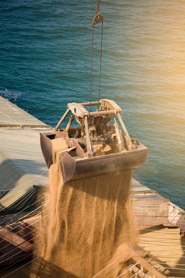 Loading Wheat on Cargo Ship with Crane and Bucket. Shipment from a ...