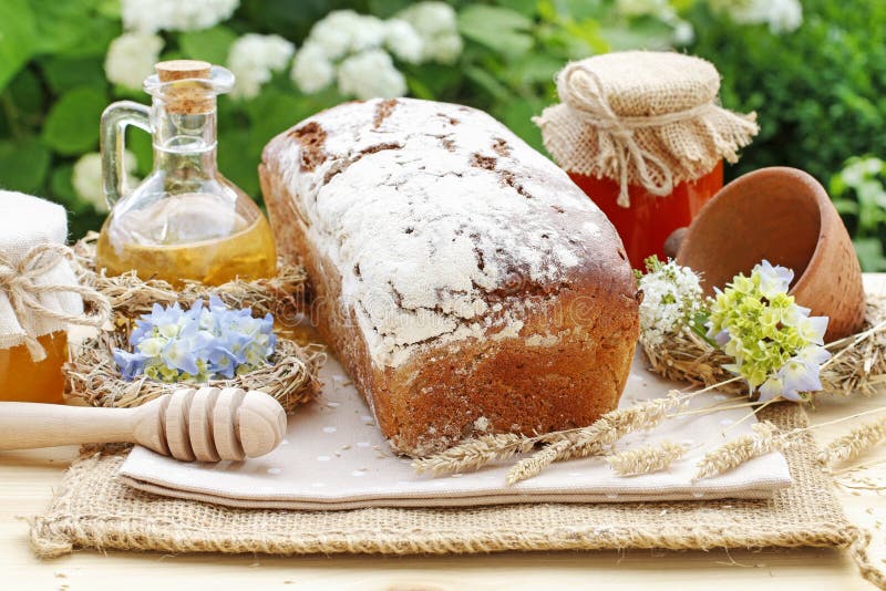 Loaf of Bread, Jar with Honey and Summer Flowers on the Table Stock ...