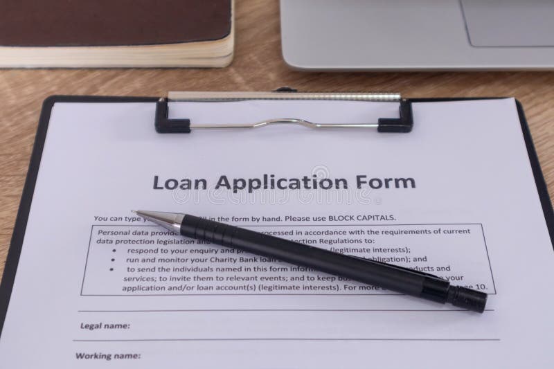 Loan Application Form on the Wooden Table with Pen, Laptop, and ...