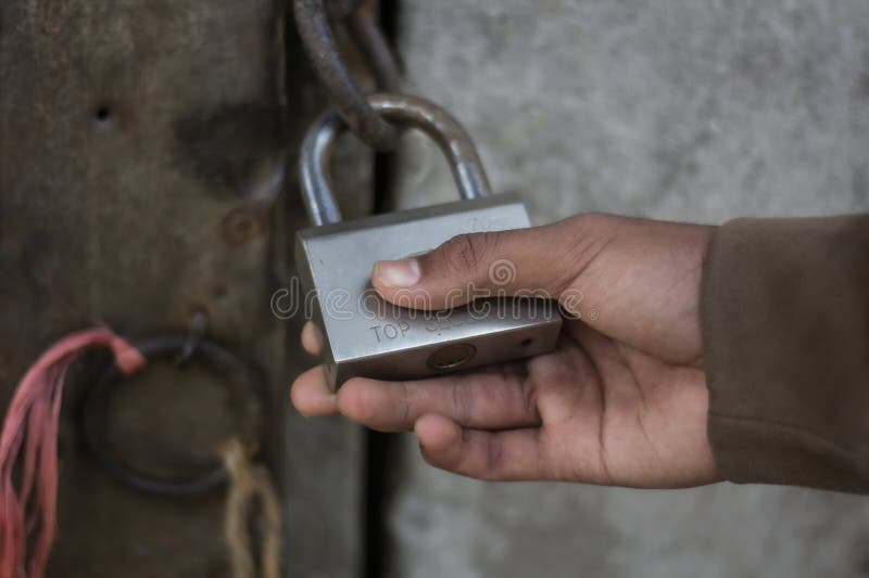 A Lock Hangs on a Door and a Person Holds the Lock Stock Photo - Image ...