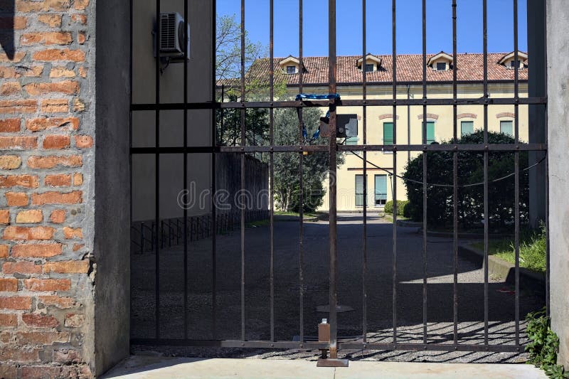 Locked Gate and a Building at the End of a Path in a Garden Behind it ...