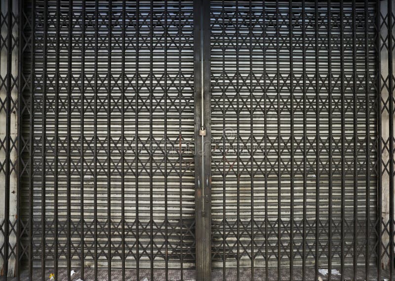 A Locked Metal Gate Secures a Closed Storefront Stock Photo - Image of ...