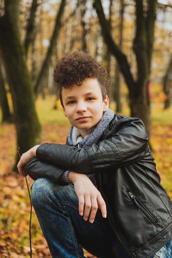 Ein Curlyhaired Brownhaired Junge Mit Einer Mohikanerfrisur In Einer
