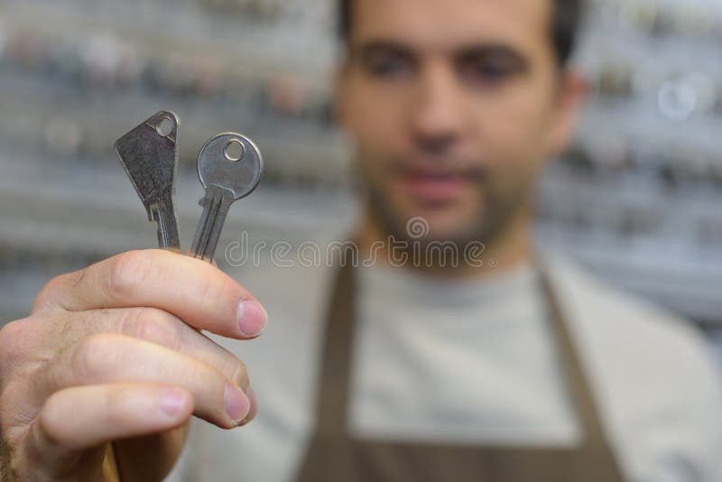 Locksmith holding two keys stock photo. Image of working - 118890864