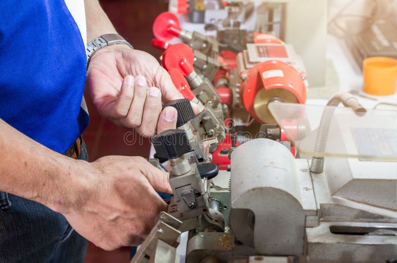 Locksmith in Workshop Makes New Key. Professional Making Key in ...