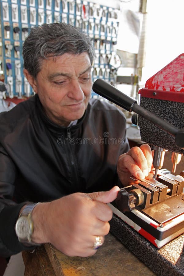 Locksmith in Workshop Makes New Key. Professional Making Key in ...