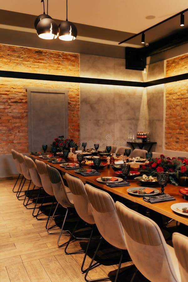 In a Loft-style Restaurant There is a Long Table Served with Glasses ...