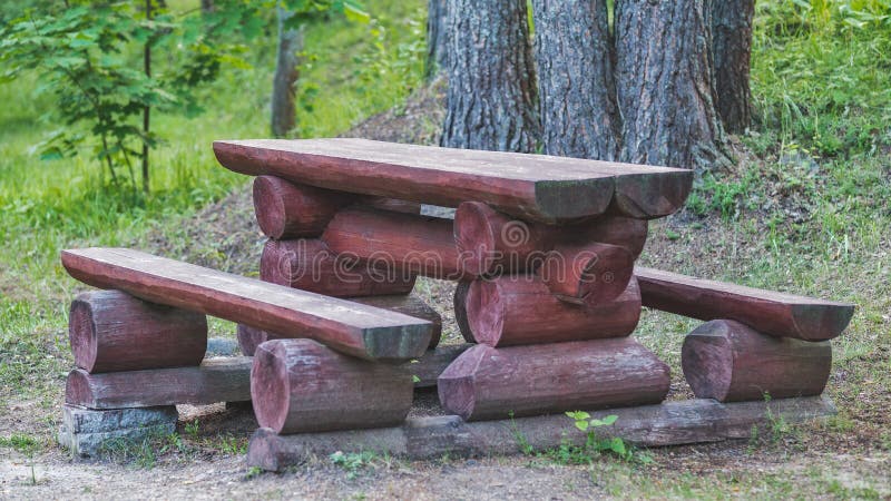 A Log Bench and Table in the Park Against a Background of Green Grass ...