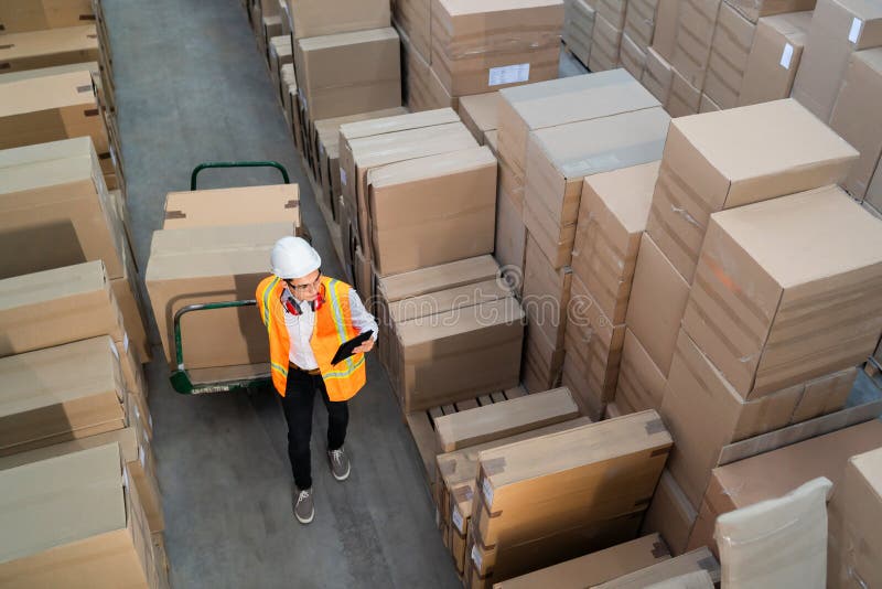 Logistic Warehouse Worker Delivering Boxes on a Trolley. Stock Photo ...