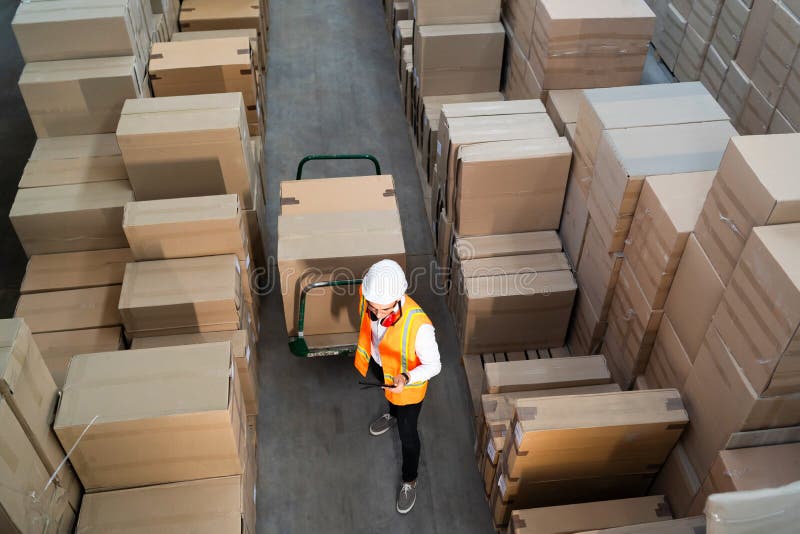 Logistic Warehouse Worker Delivering Boxes on a Trolley. Stock Photo ...