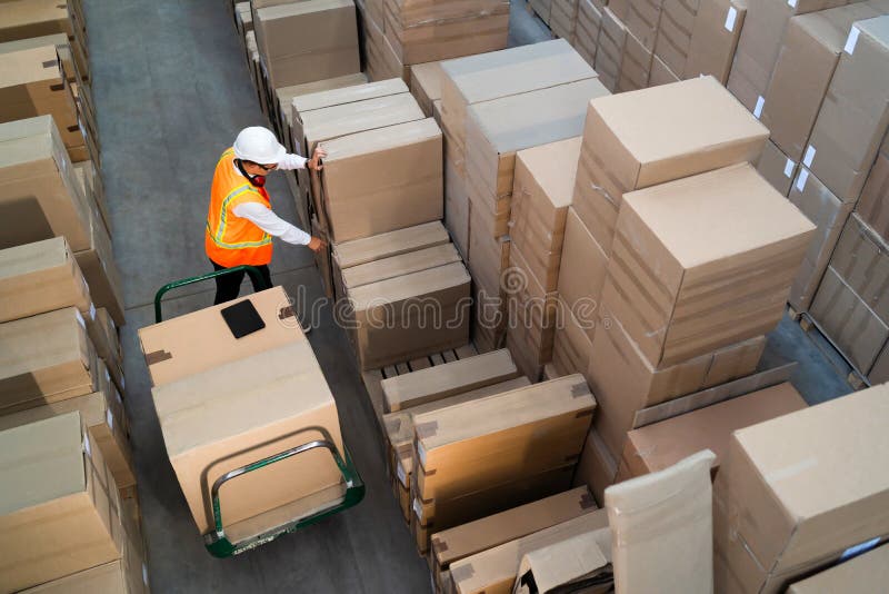 Logistic Warehouse Worker Delivering Boxes on a Trolley. Stock Photo ...