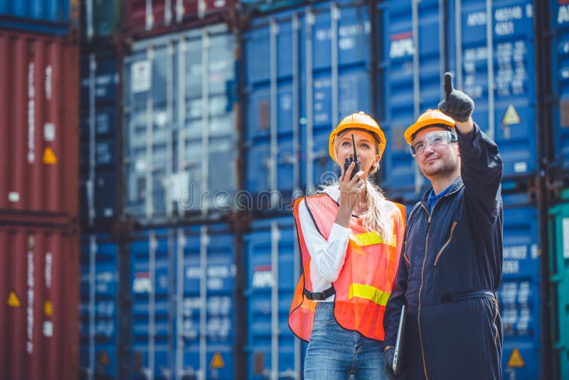Logistic Worker Man And Woman Working Team With Radio Control Loading Containers At Port Cargo