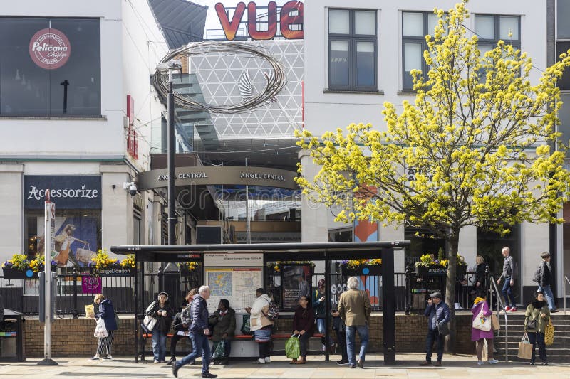 People Waiting at a Bus Stop in Front of Shops in London Editorial ...