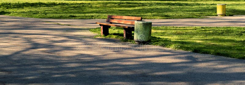 A lone bench in a park stock image. Image of road, grass - 82935557