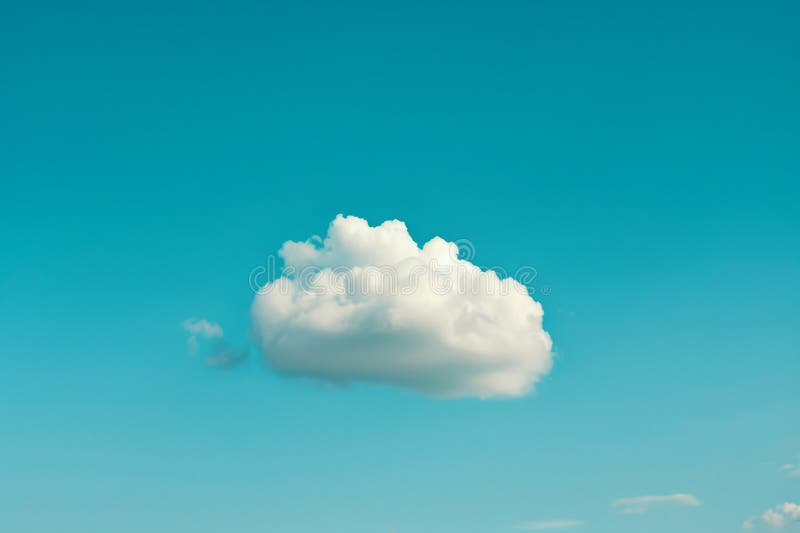 A Lone Cloud Peacefully Floats in the Blue Sky on a Sunny Day, a Single ...