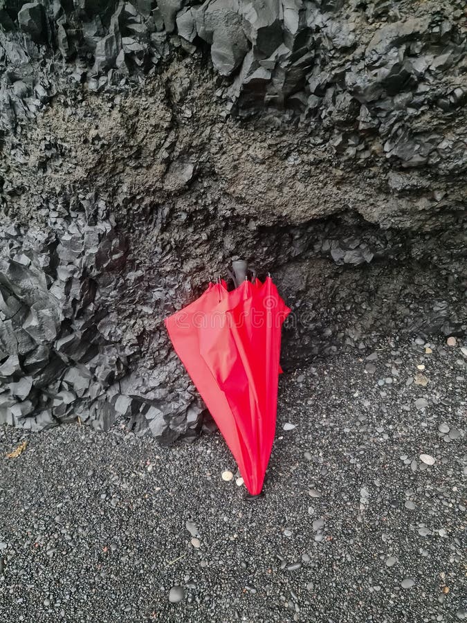 A Lone Red Umbrella on the Endless Black Beaches of Iceland in Front of ...