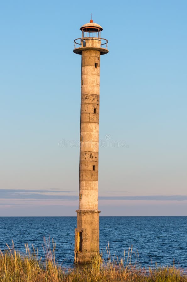 A Lone Lighthouse in Golden Morning Light. Stock Image - Image of ...