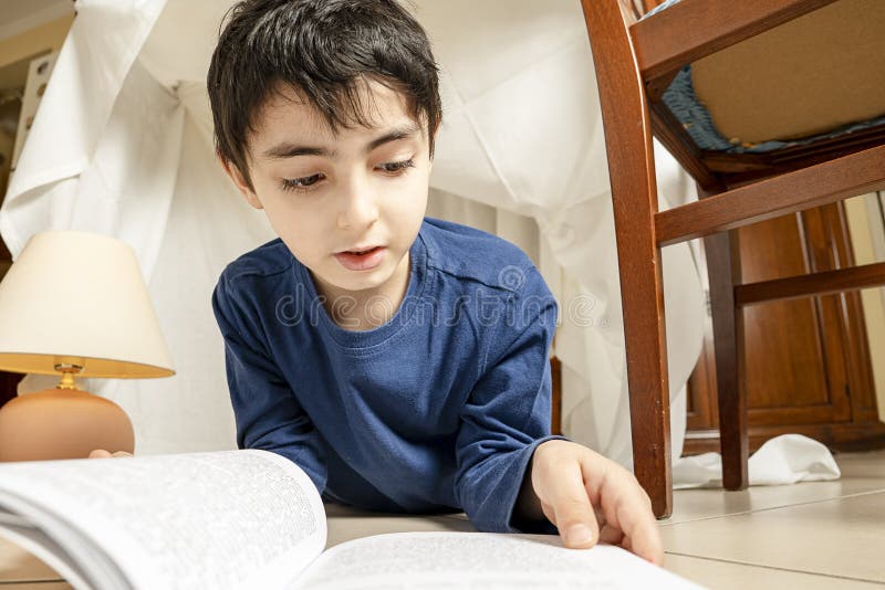 Lonely Caucasian Child Reading a Book at Home in Isolation Stock Photo ...