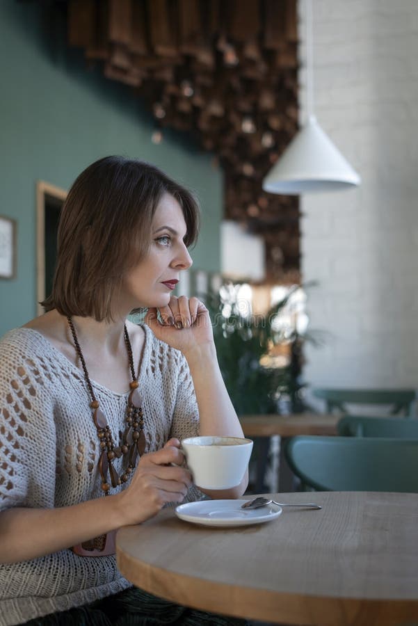 Lonely Lady in the Cafeteria. Brooding Woman in an Empty Cafe with Cup ...