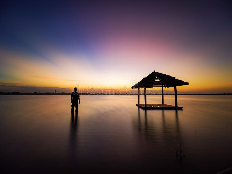 A Lonely Man Looking at the Beautiful Sunset at the Flooded Rice Field ...