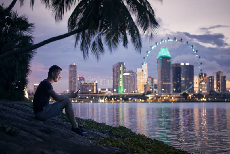 Lonely Man Using Phone Against Urban Skyline at Twilight Stock Image ...