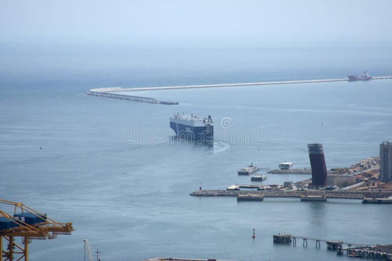 Cargo Ship Moving through Water with a Breakwater in the Background ...