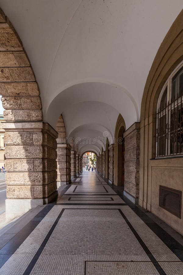 A Long, Arched Colonnade with a Patterned Floor and Stone Pillars ...