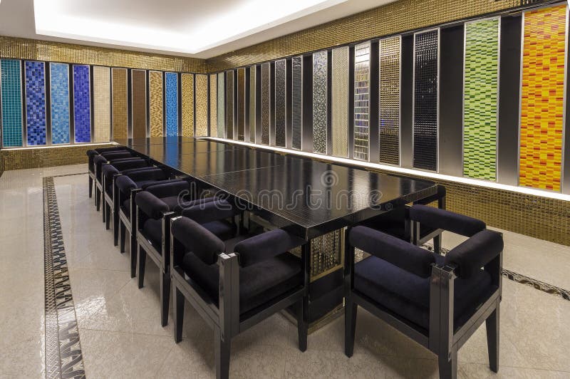 Long Black Table with Chairs in a Room with Decorated and Tiled Walls ...