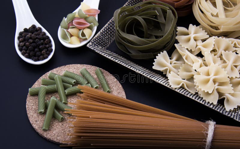 Long Brown Pasta and Shaped Pasta and Colored Pasta in a Bowl and Black ...