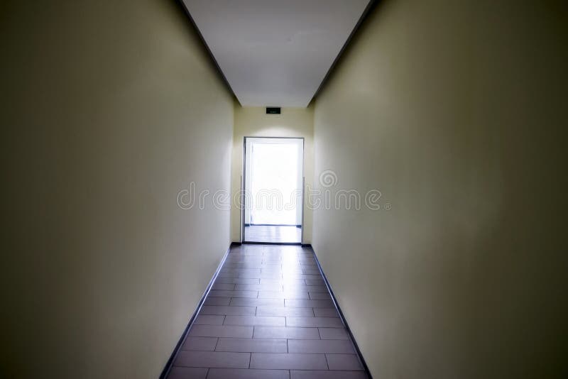 A Long Corridor with an Open Door. a Bright Light Shines from the Open ...