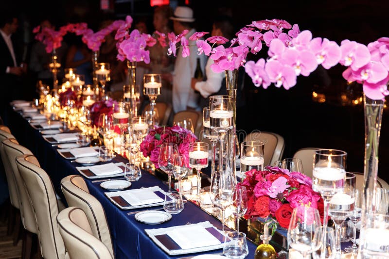 Long Dinner Table Decorated with Gold, Shiny Candles and Red Flowers ...