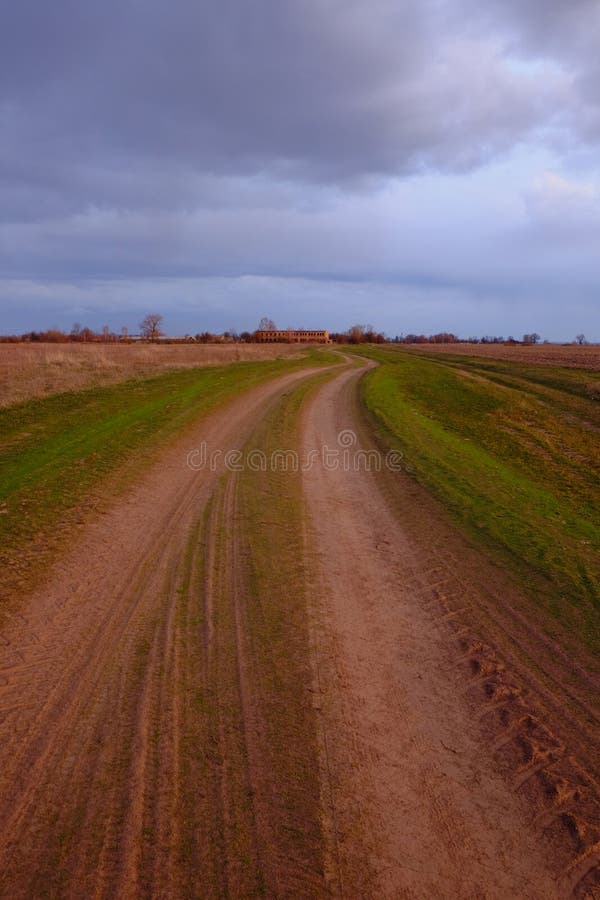 Long Dirt Road in the Fields. Cloudy Evening Landscape Stock Image ...