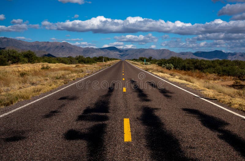 Long Empty Road in the Middle of a Desert with Mountains in the ...