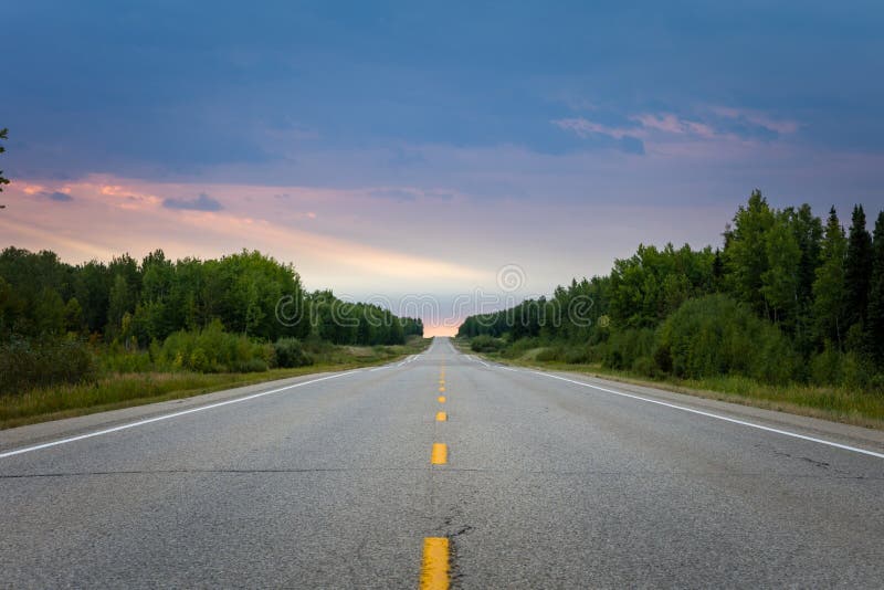 Long Empty Road Surrounded by Trees and a Dramatic Sky Stock Photo ...