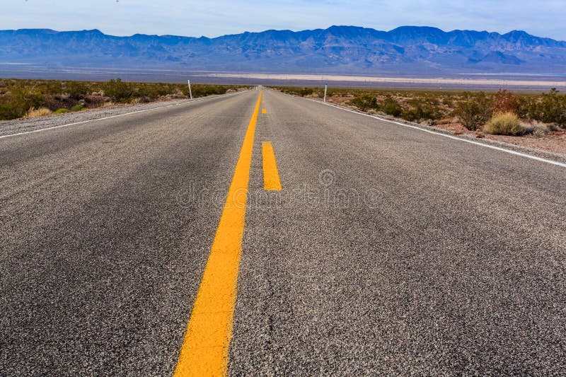 A Long, Empty Road with a Yellow Line Down the Middle Stock Photo ...